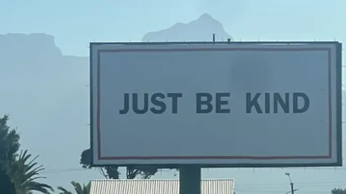 What's the meaning behind the 'Just Be Kind' billboards in Cape Town?
